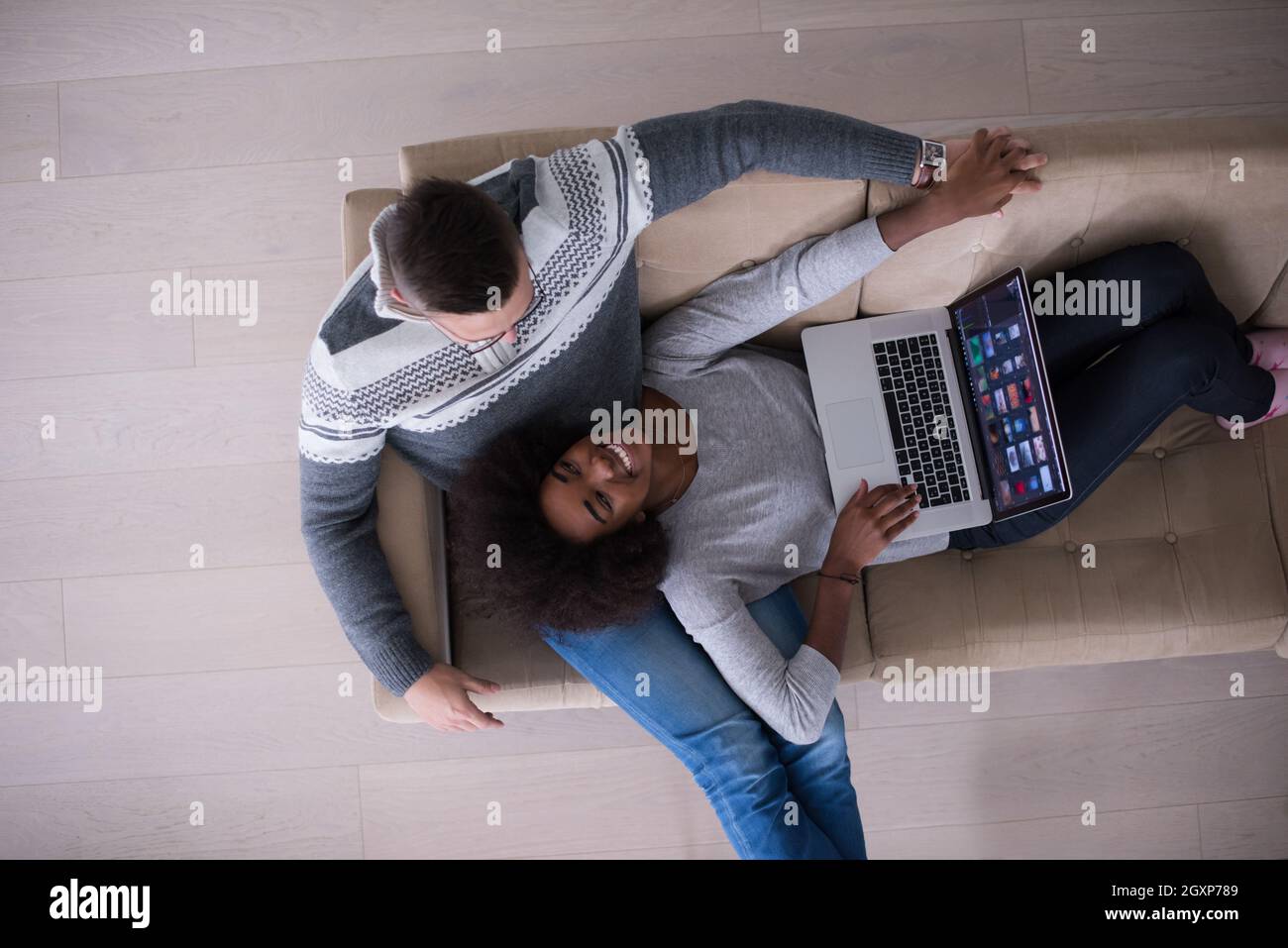 Young multiethnic couple relaxes in the luxury living room, using a ...