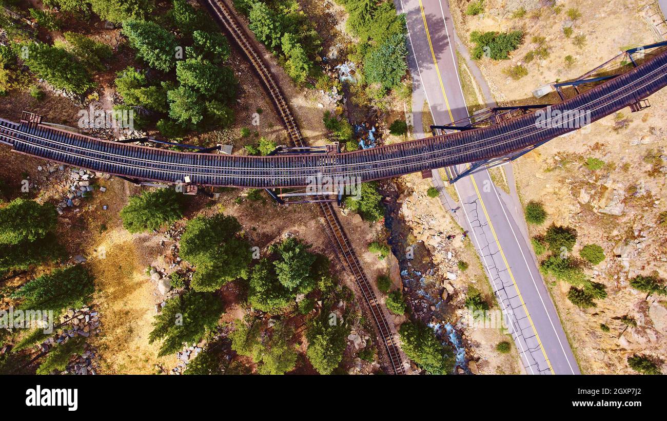 Aerial of train tracks crossing over tracks and road in desert Stock ...