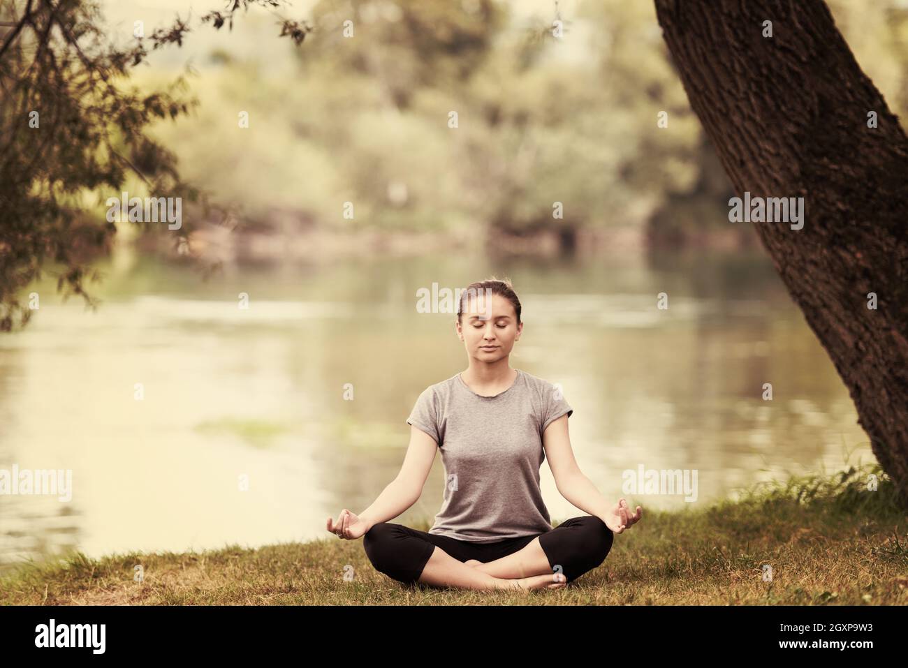 healthy woman relaxing while meditating and doing yoga exercise in the ...