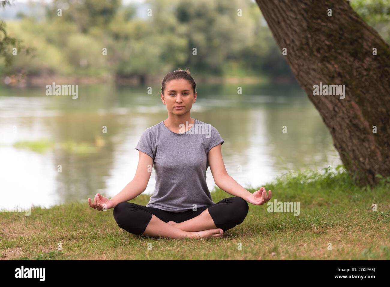 healthy woman relaxing while meditating and doing yoga exercise in the ...