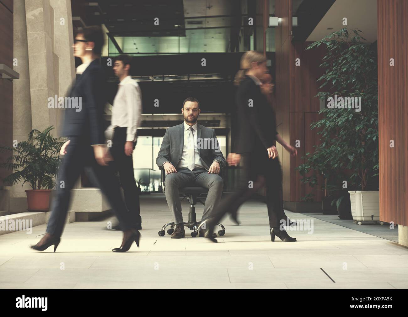 business man sitting in office chair, people group passing by: Concept ...