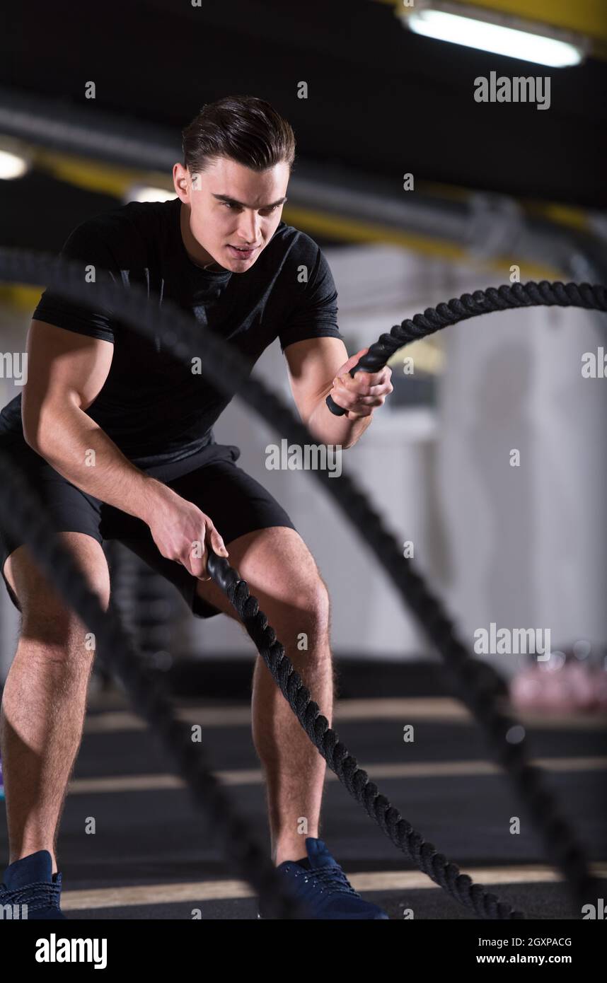 young fit athlete man working out in functional training gym doing ...