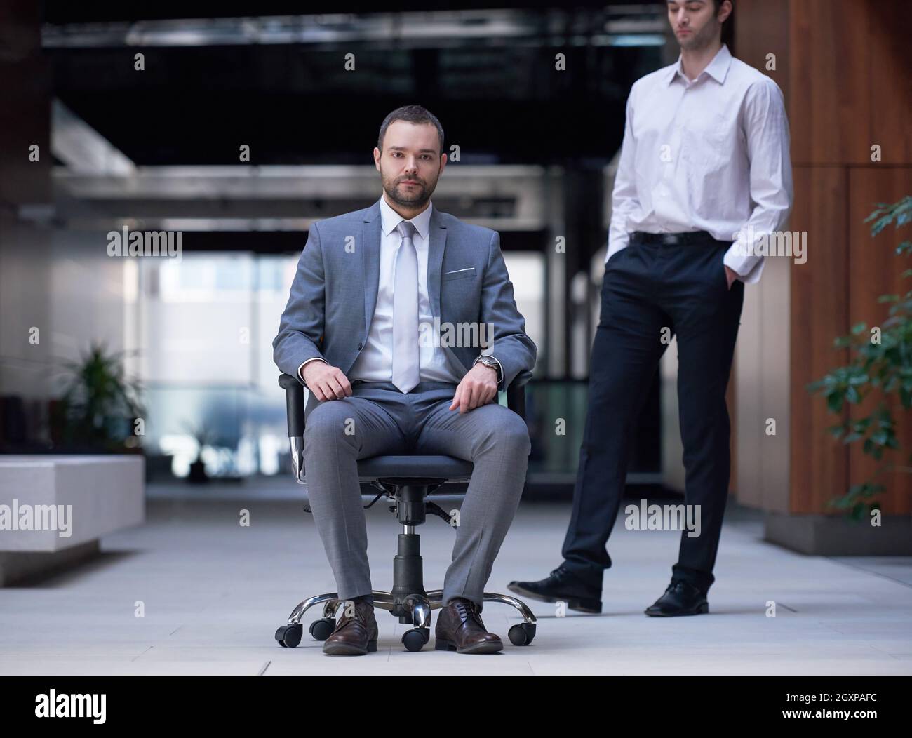 business man sitting in office chair, people group passing by: Concept ...