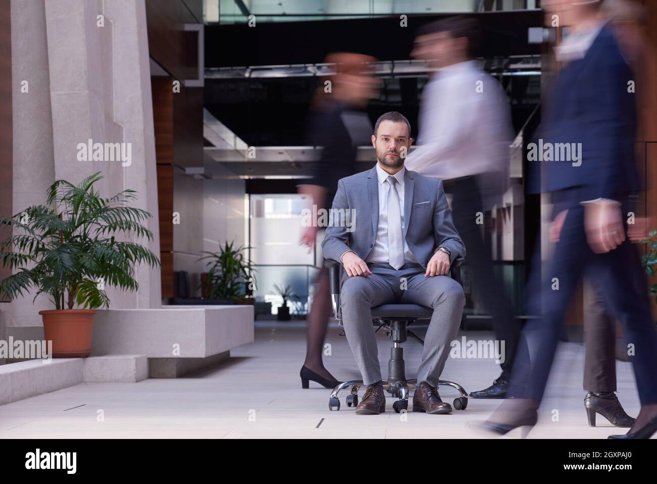 business man sitting in office chair, people group passing by: Concept ...