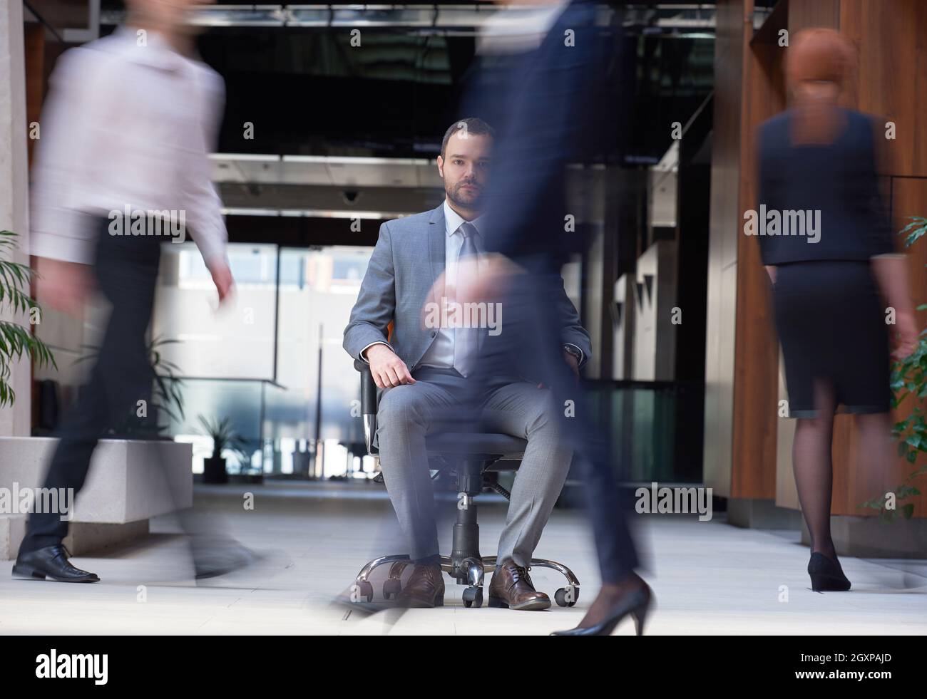 business man sitting in office chair, people group passing by: Concept ...