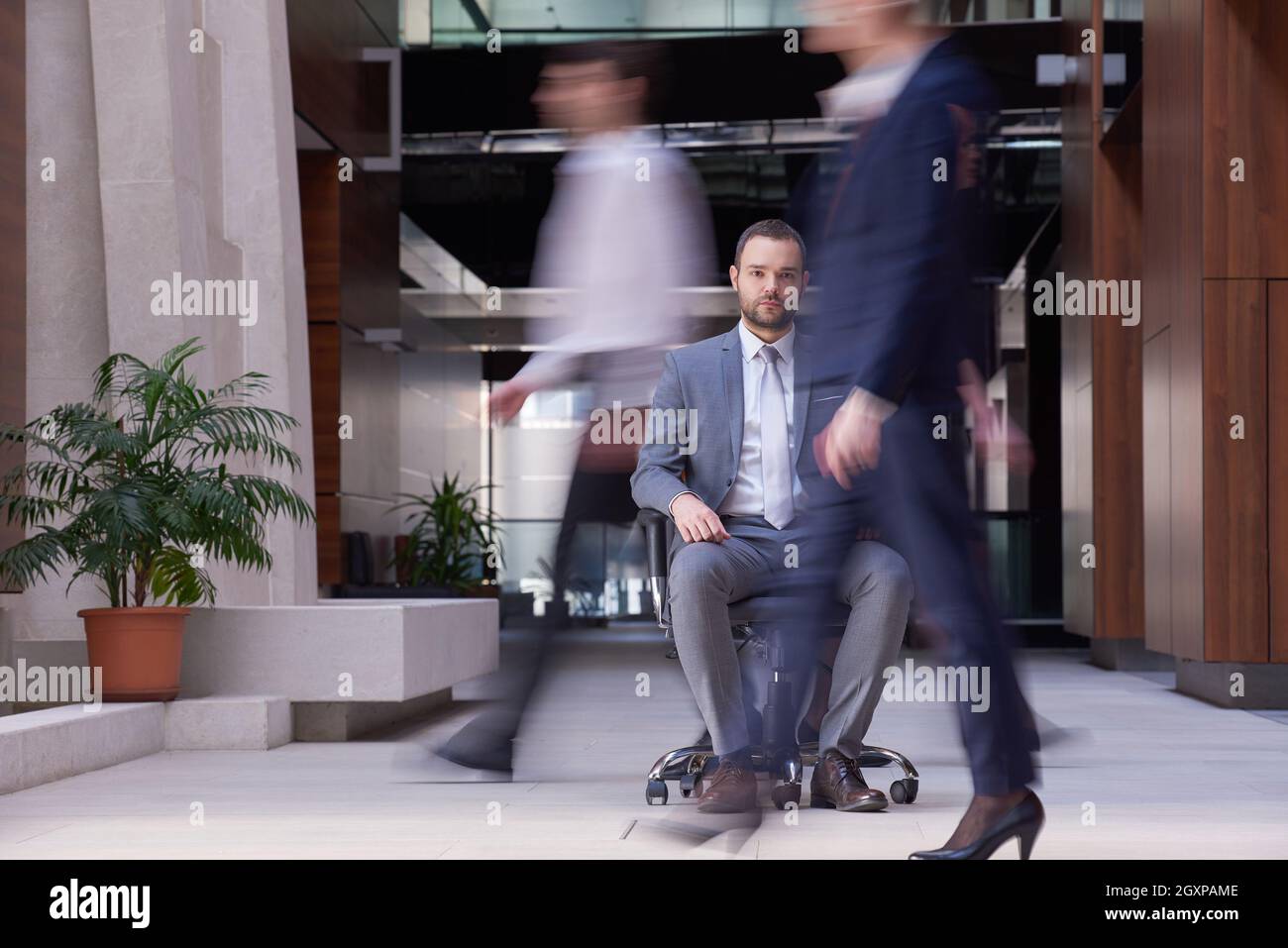 business man sitting in office chair, people group passing by: Concept ...