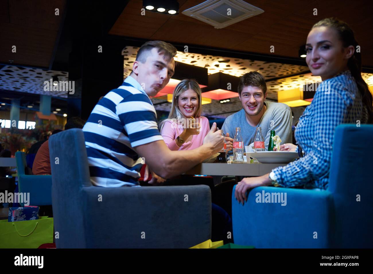 friends have lanch break in shopping mall, eating italian fast food ...