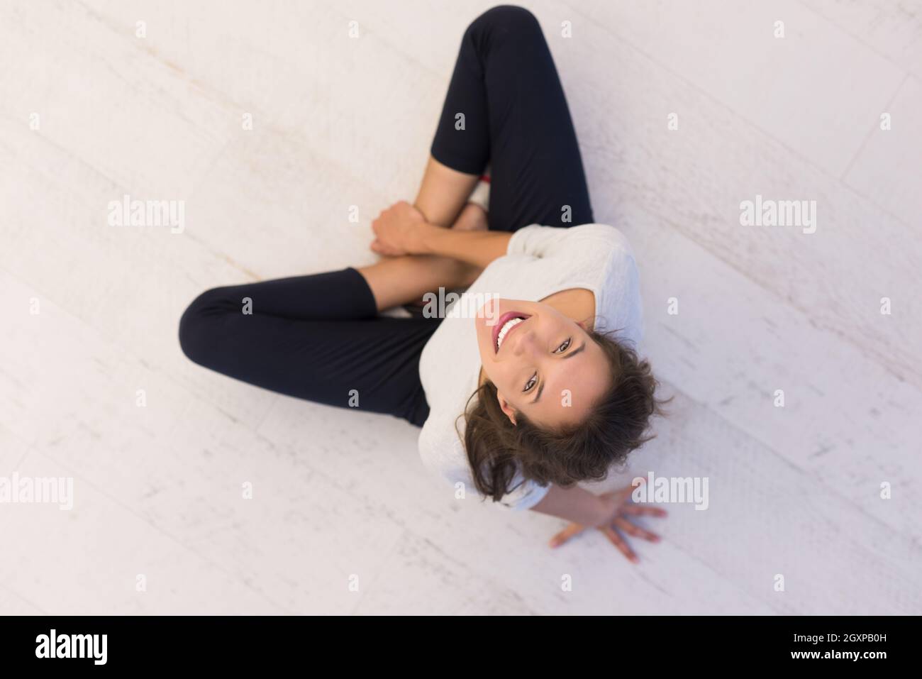 top view of young woman sitting on the floor and smiling Stock Photo ...
