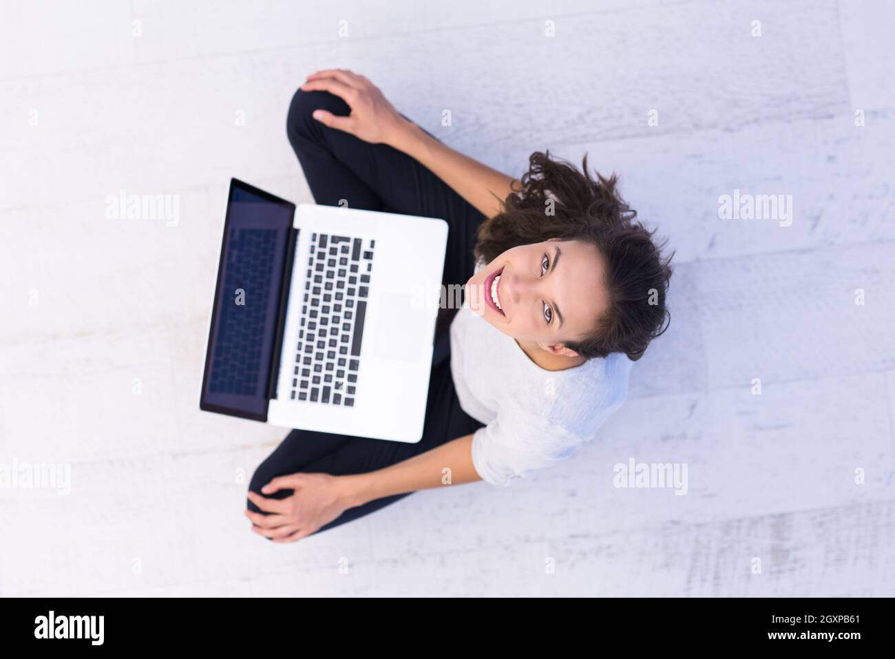 top view of a beautiful young women using laptop computer on the floor ...