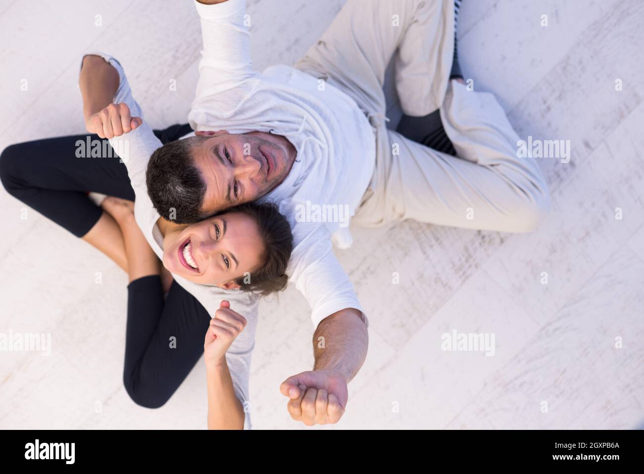top view of Cheerful young couple sitting with back to each other on ...