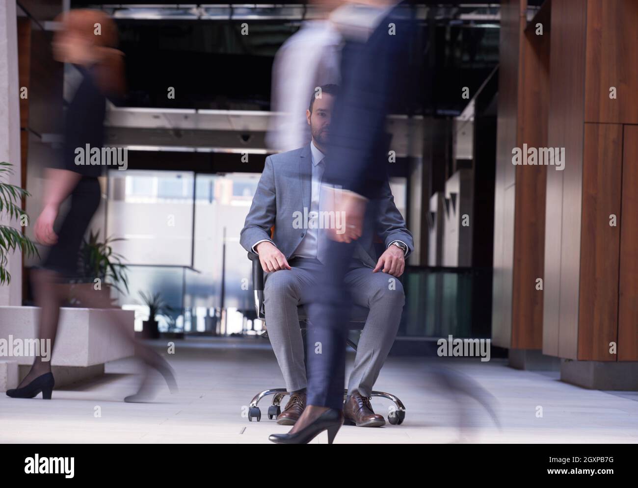 business man sitting in office chair, people group passing by: Concept ...