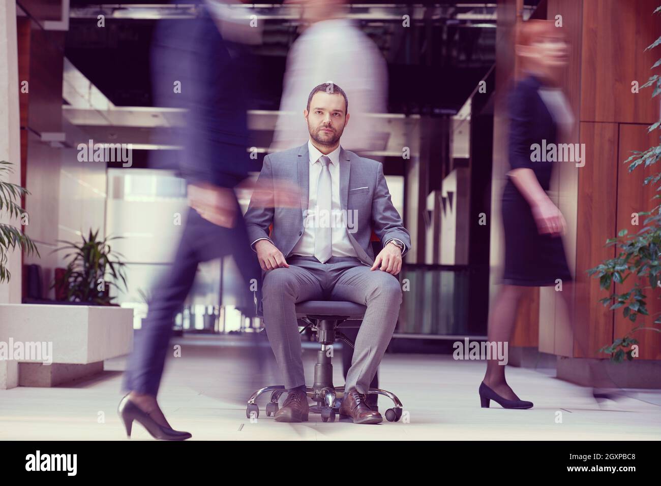 business man sitting in office chair, people group passing by: Concept ...