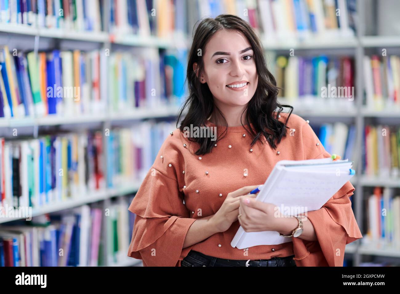 Reading a book in library. Young attractive librarian reading a book ...