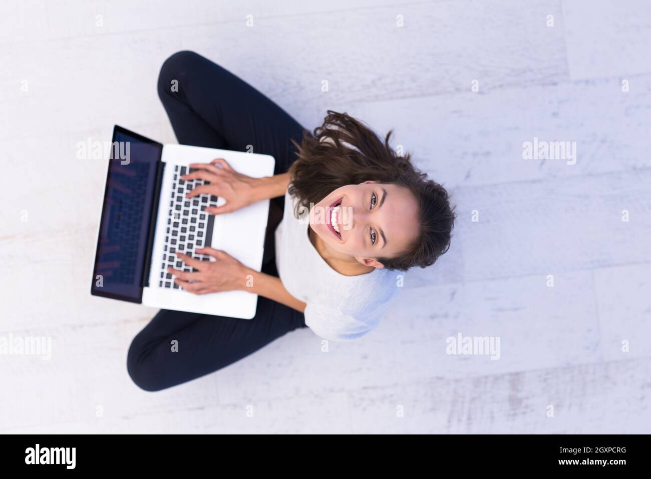 top view of a beautiful young women using laptop computer on the floor ...