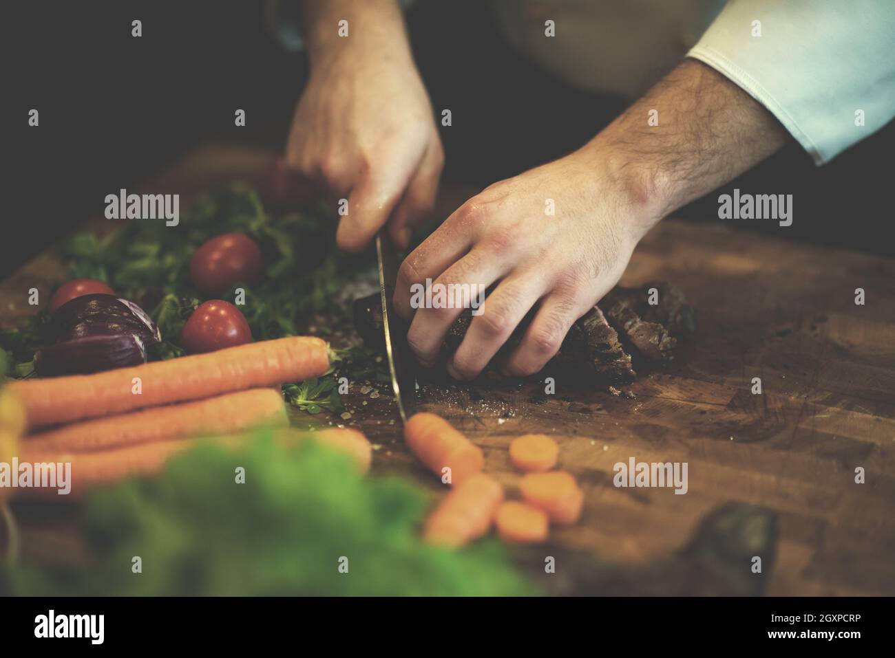 closeup of Chef hands in hotel or restaurant kitchen preparing beef ...