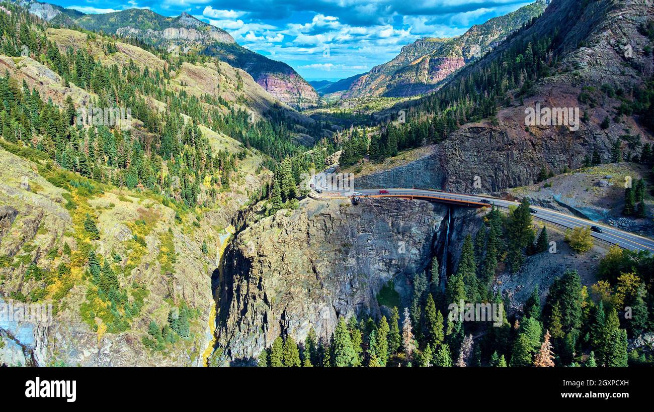 Valley in mountains with small road curving through and waterfall Stock ...