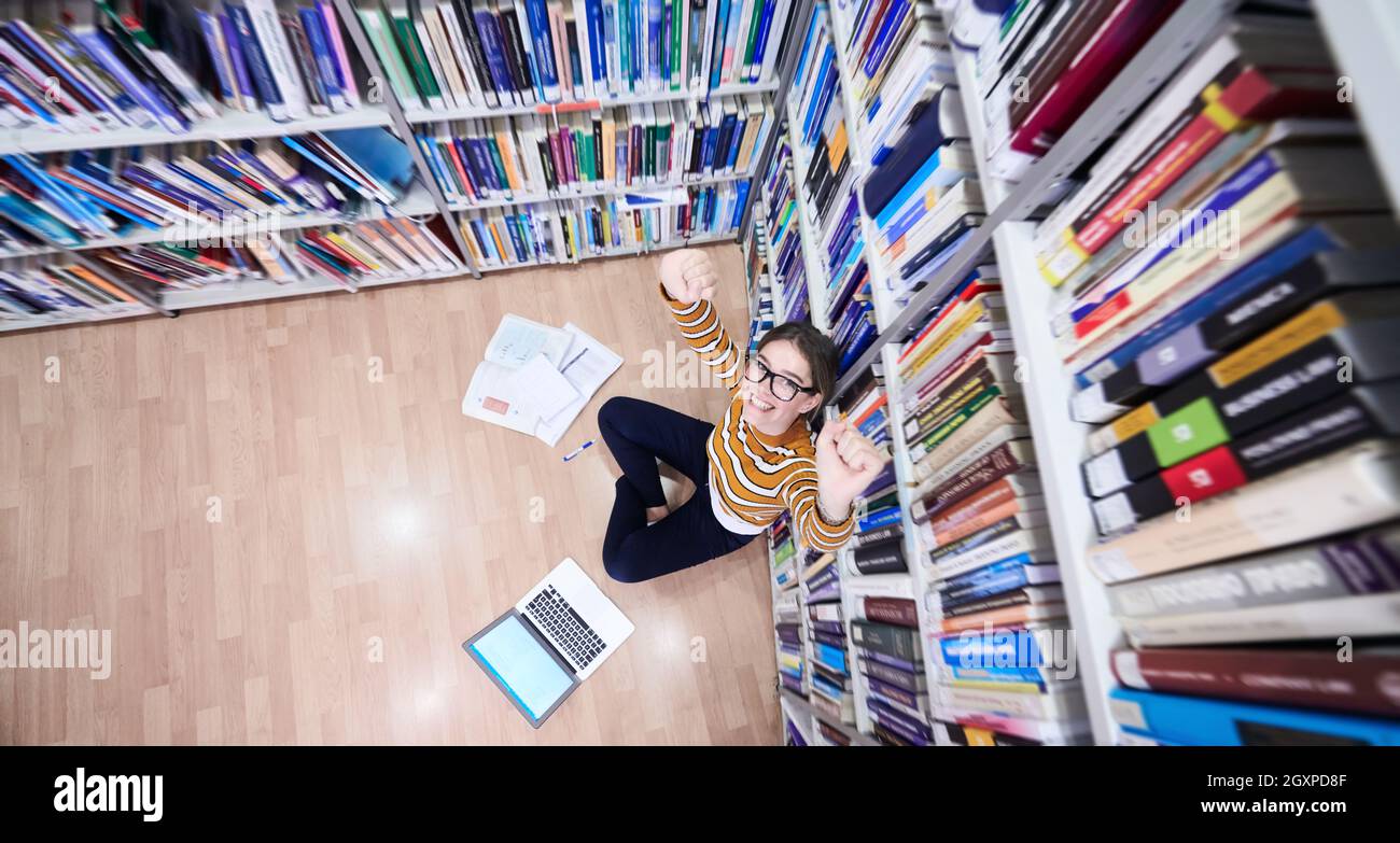 student taking notes from a book at library. Young woman sittingin in ...