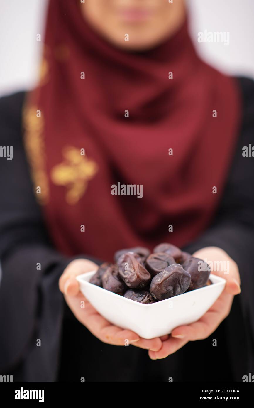 modern muslim woman holding a plate full of sweet dates on iftar time ...