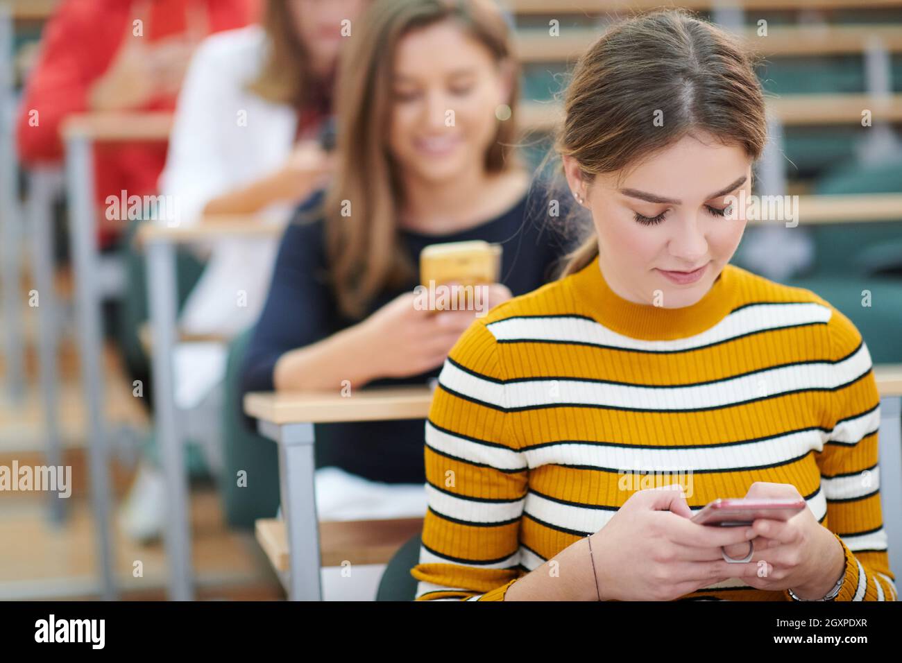 female female students use a smartphone during classroom instruction ...