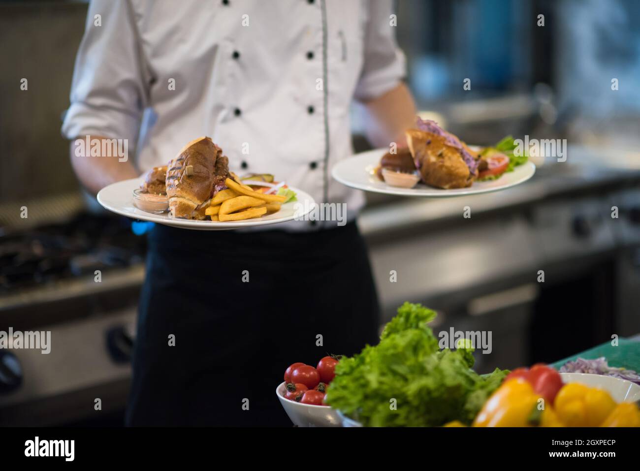 young Chef presenting dishes of tasty meals in commercial kitchen Stock ...