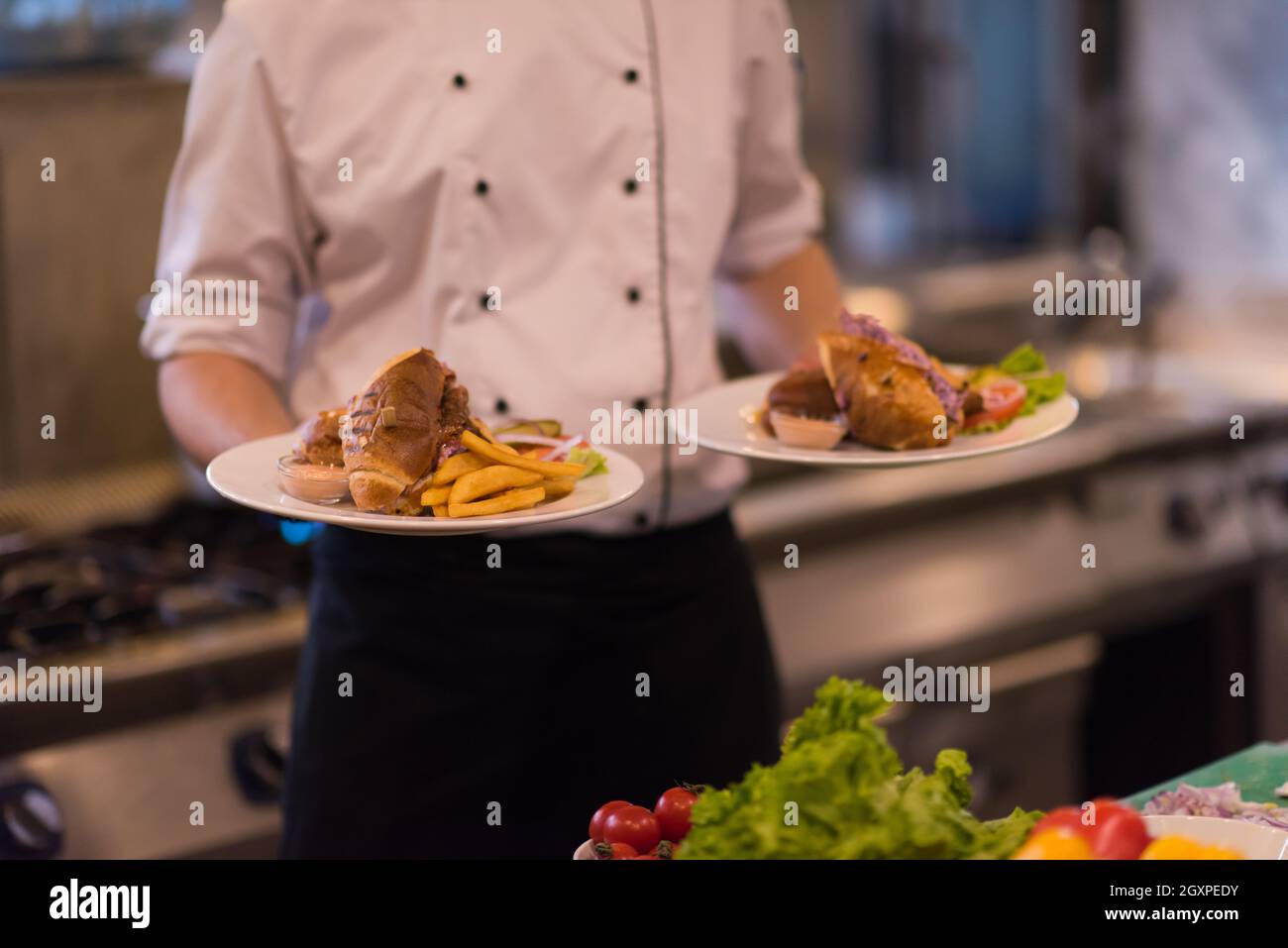 young Chef presenting dishes of tasty meals in commercial kitchen Stock ...