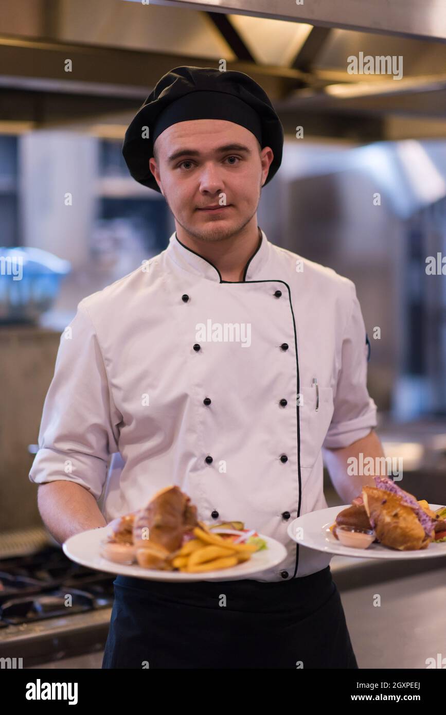young Chef presenting dishes of tasty meals in commercial kitchen Stock ...