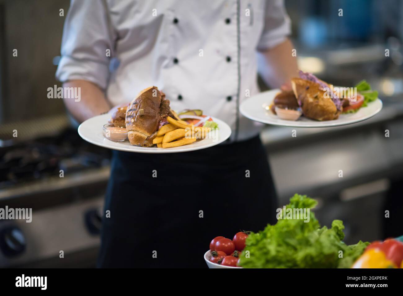 young Chef presenting dishes of tasty meals in commercial kitchen Stock ...
