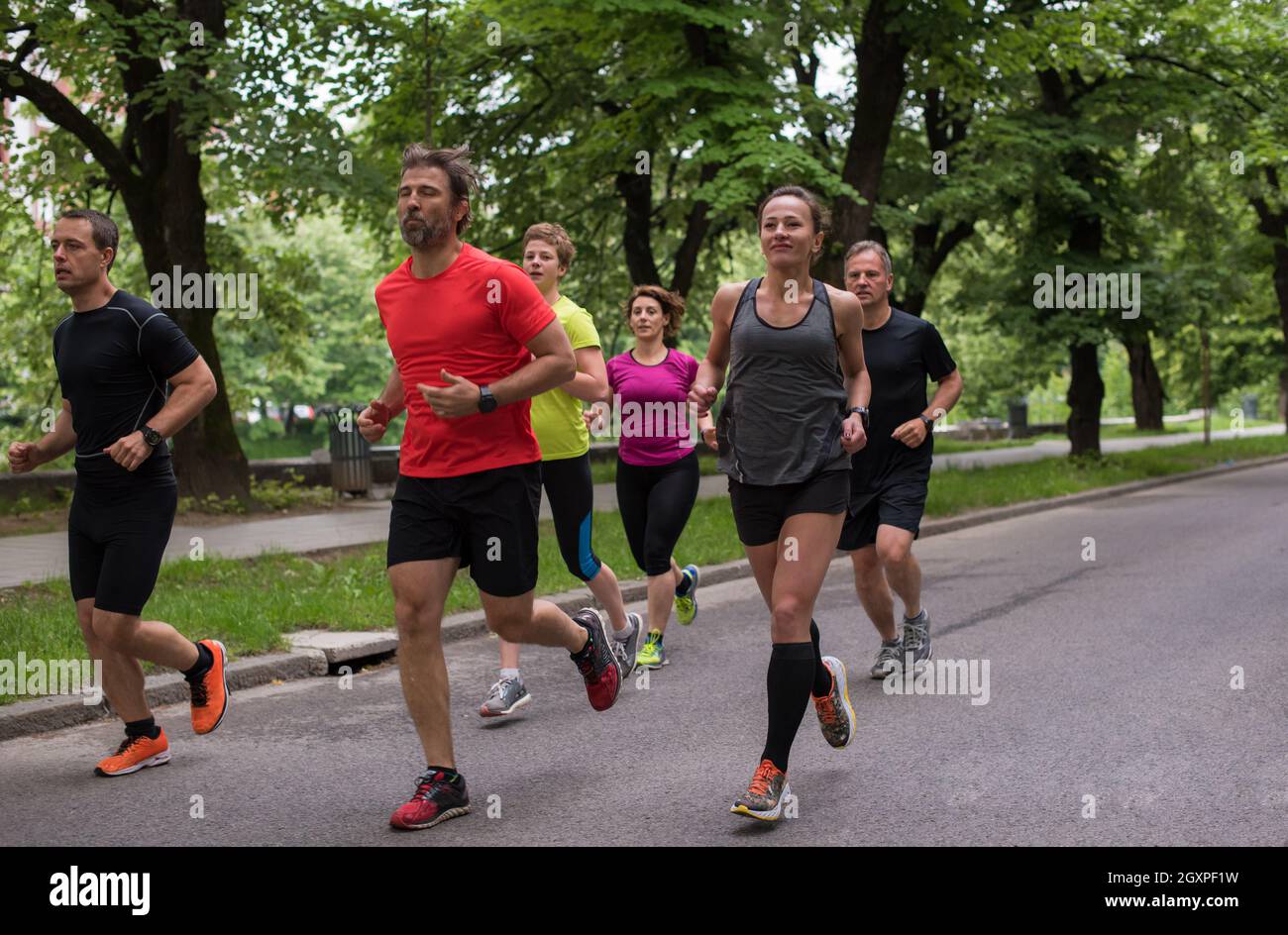 group of healthy people jogging in city park, runners team on morning ...