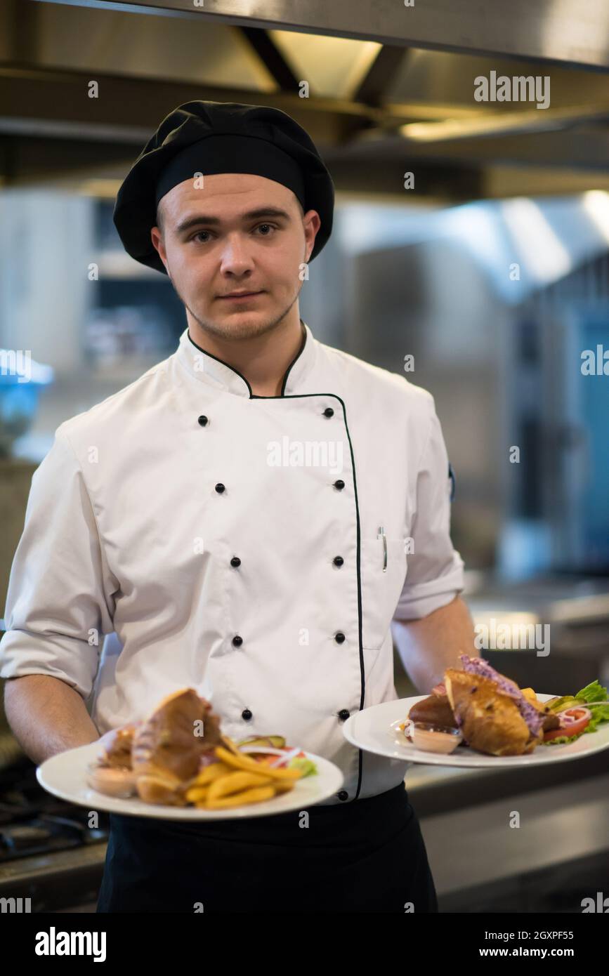 young Chef presenting dishes of tasty meals in commercial kitchen Stock ...