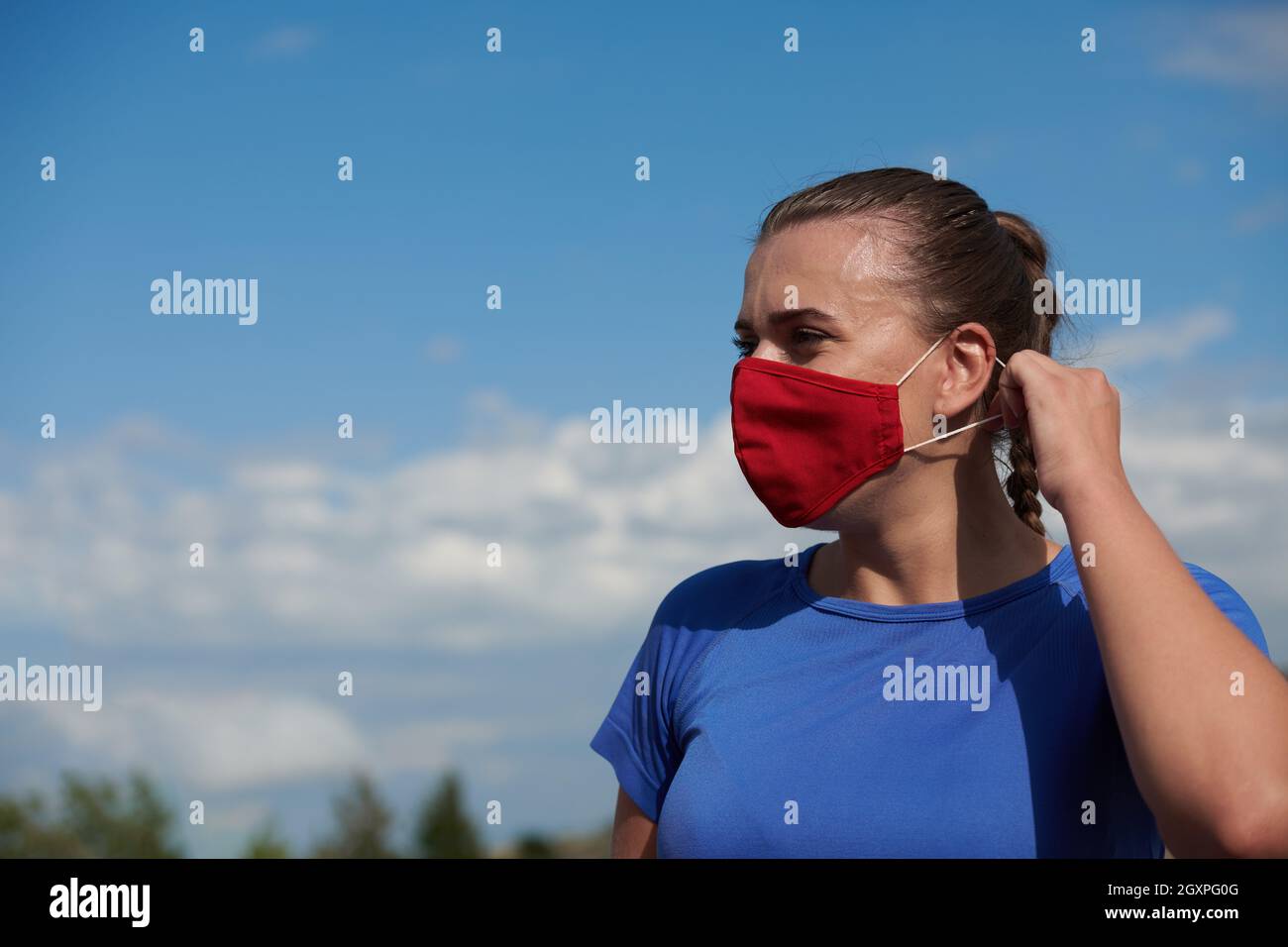 sporty woman with protective face mask having a break and relaxing ...