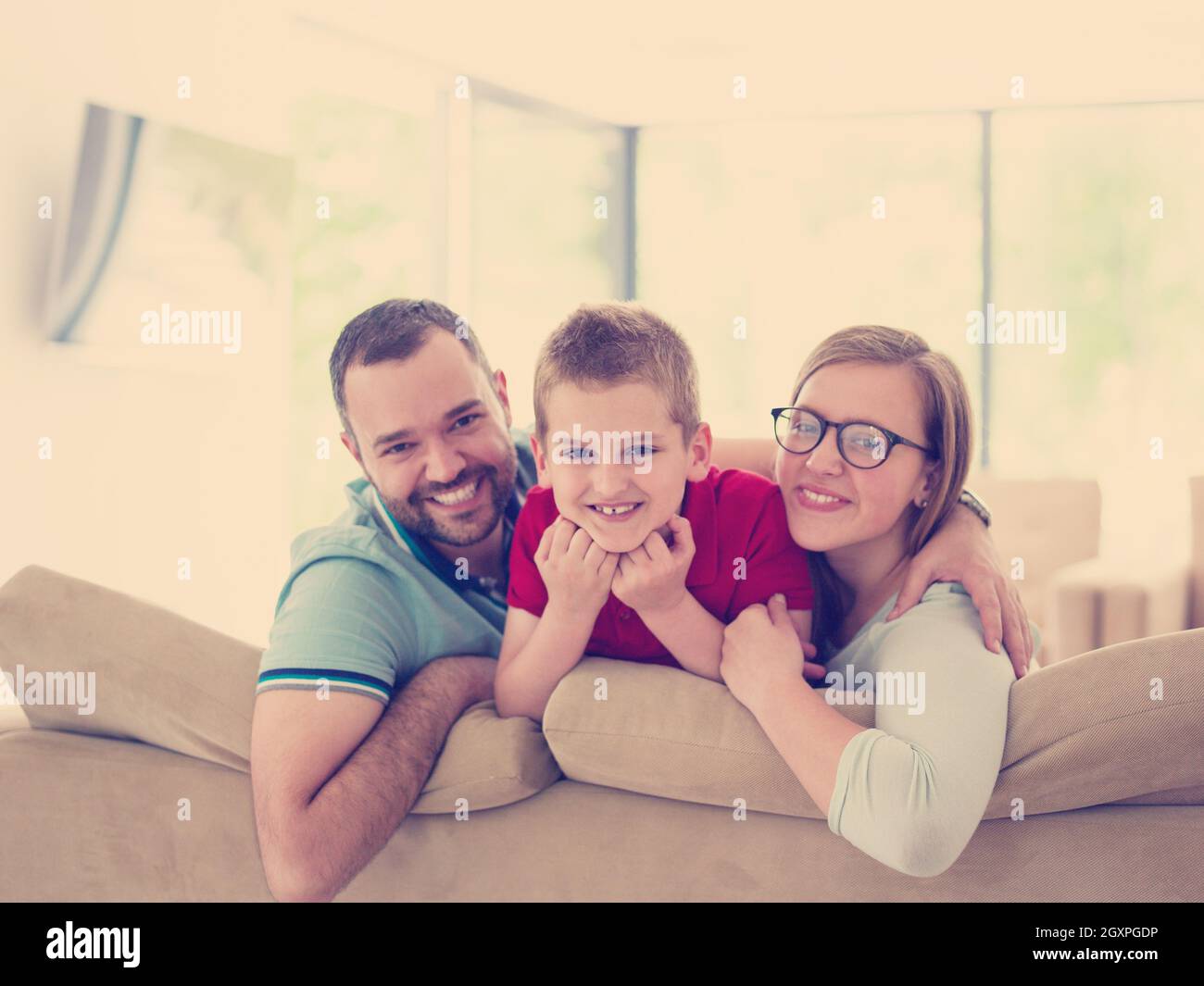 happy young family with little boy enjoys in the modern living room of ...