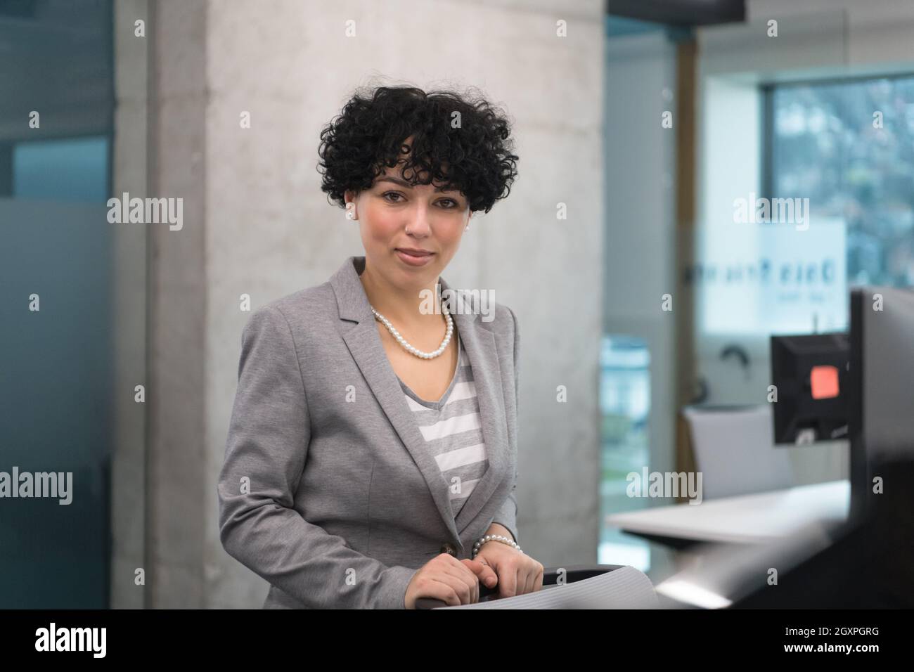 Portrait of successful female software developer with a curly hairstyle ...
