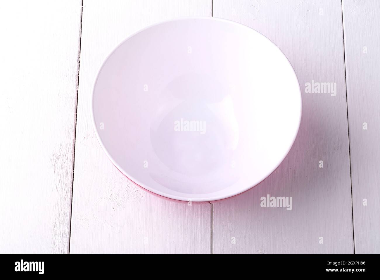 An empty red Salad Bowl on white wooden table photographed from above ...