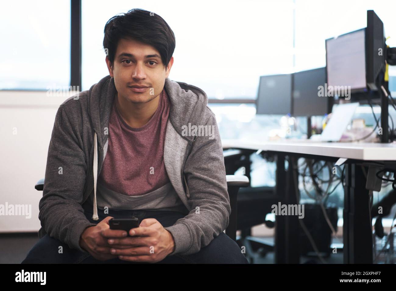 young indian male software developer using mobile phone writing ...