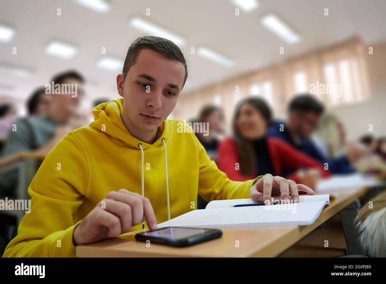 a portrait of a concentrated Student using a calculator while ...
