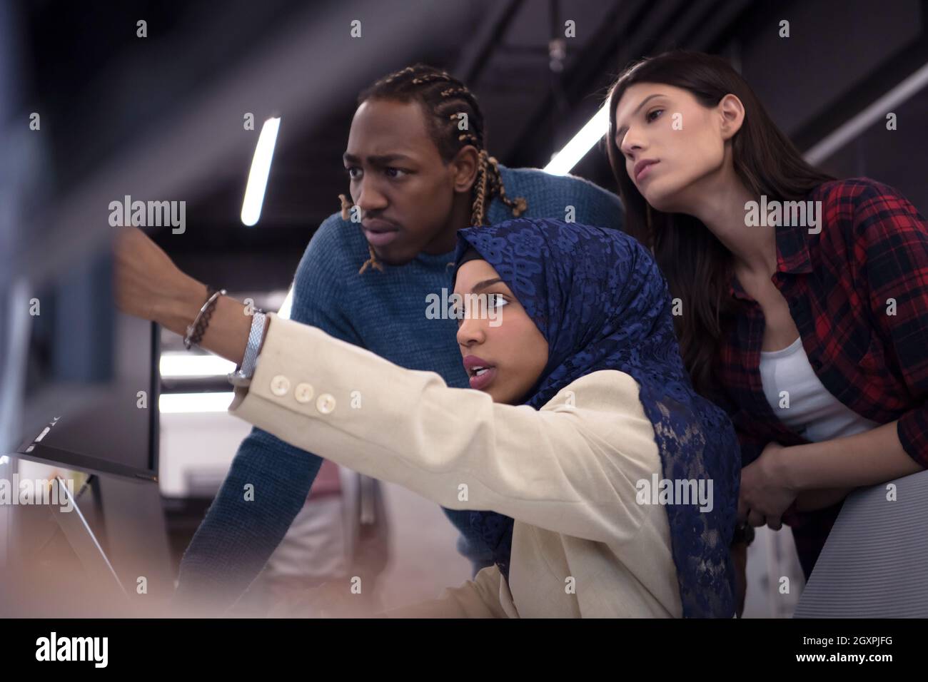 young multiethnics business team of software developers working together using laptop computer ...