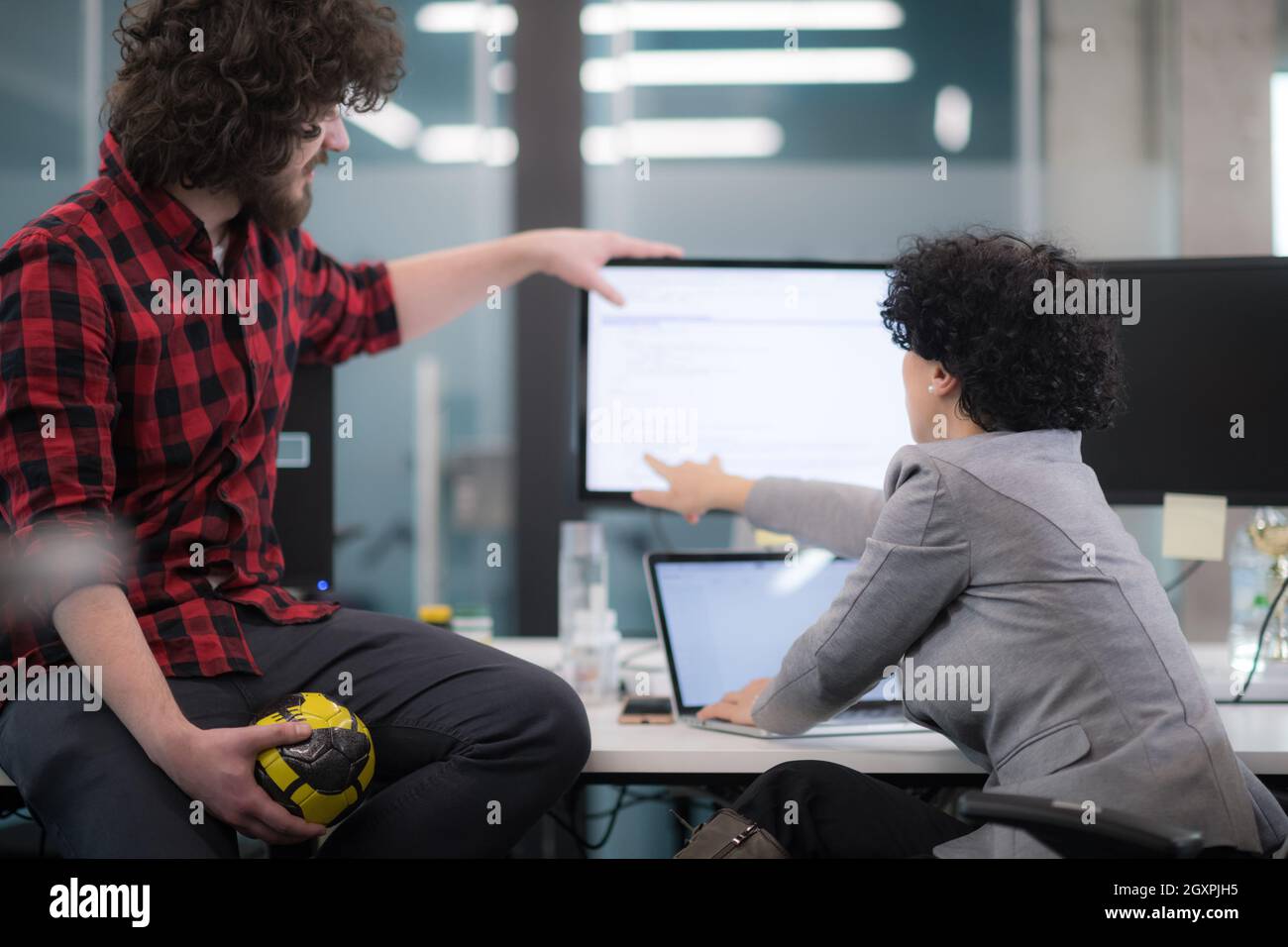 young software developers couple using laptop and desktop computer ...