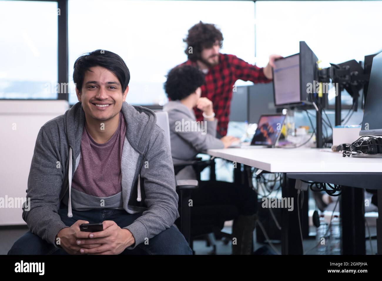 young indian male software developer using mobile phone writing ...