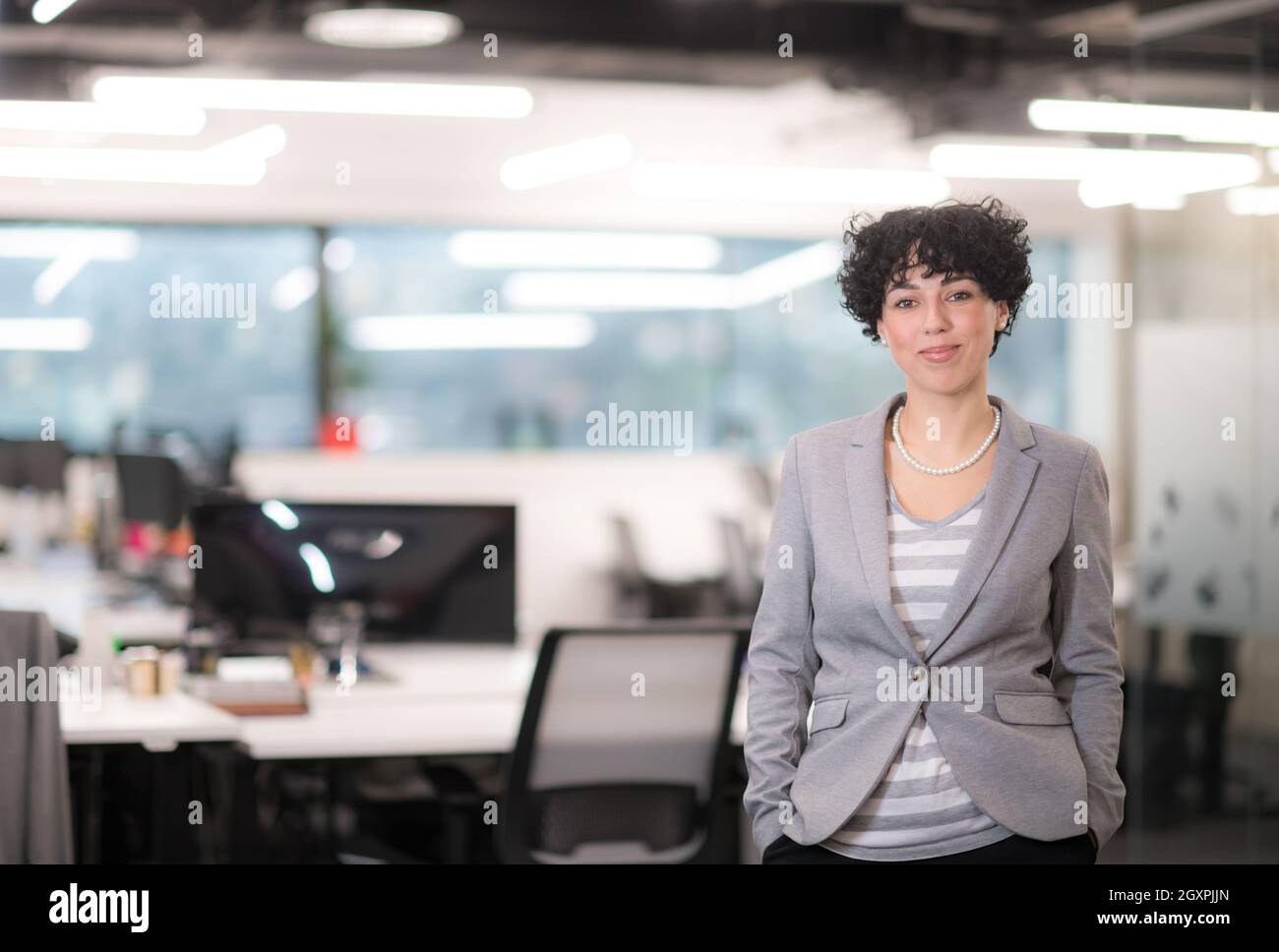 Portrait of successful female software developer with a curly hairstyle ...