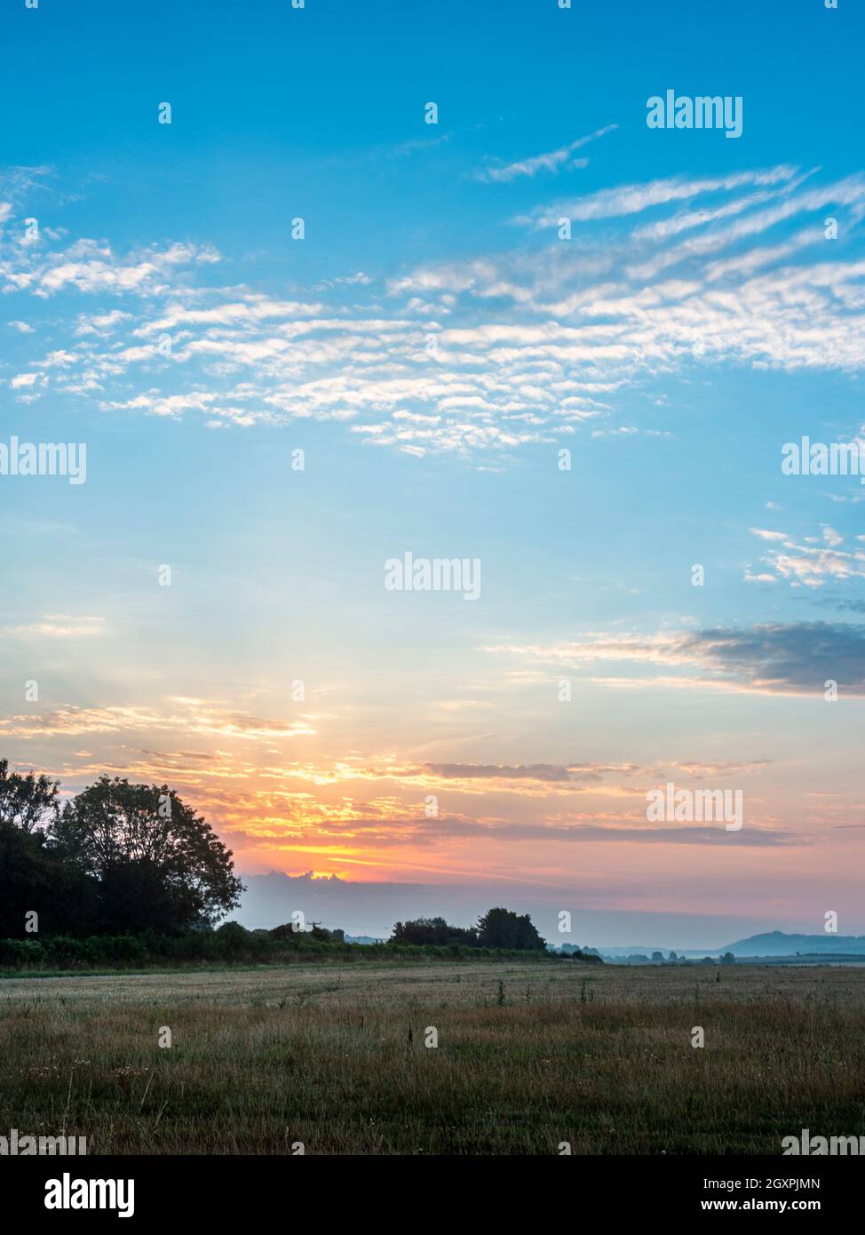 Dawn on a mid August morning as daybreaks with an orange glow and ...