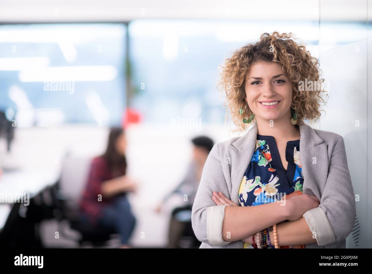 Portrait of successful female software developer with a curly hairstyle ...
