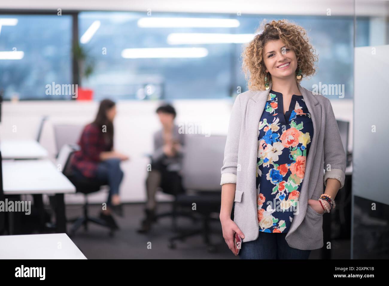 Portrait of successful female software developer with a curly hairstyle ...