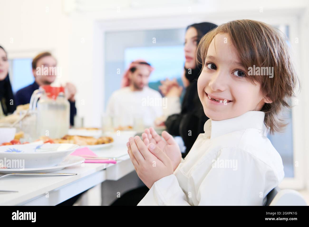 little muslim boy praying with traditional family before having iftar ...