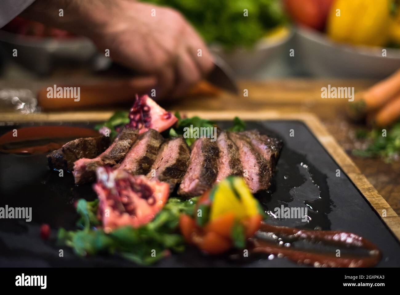 closeup of Chef hands in hotel or restaurant kitchen serving beef steak ...