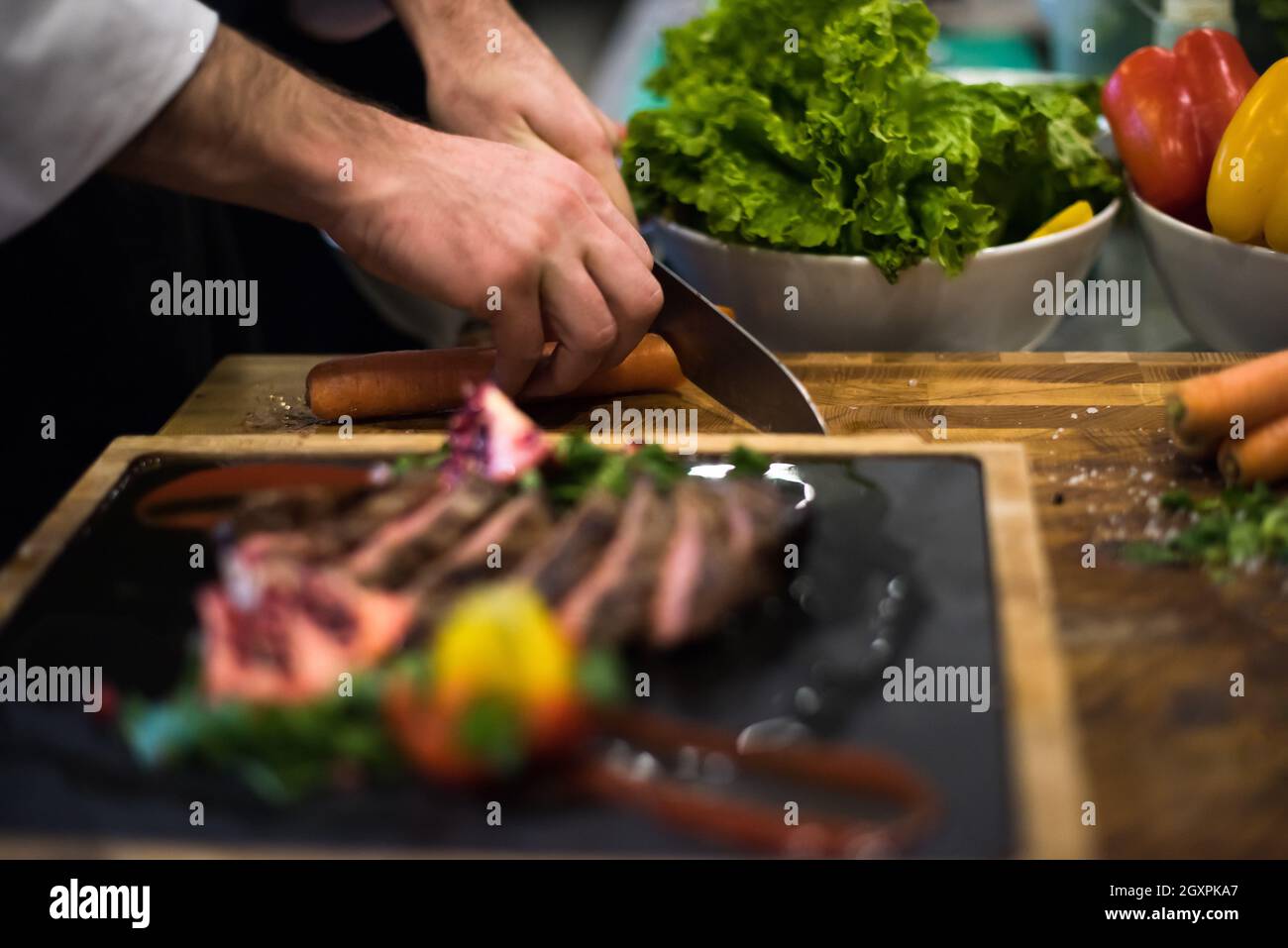 closeup of Chef hands in hotel or restaurant kitchen serving beef steak ...