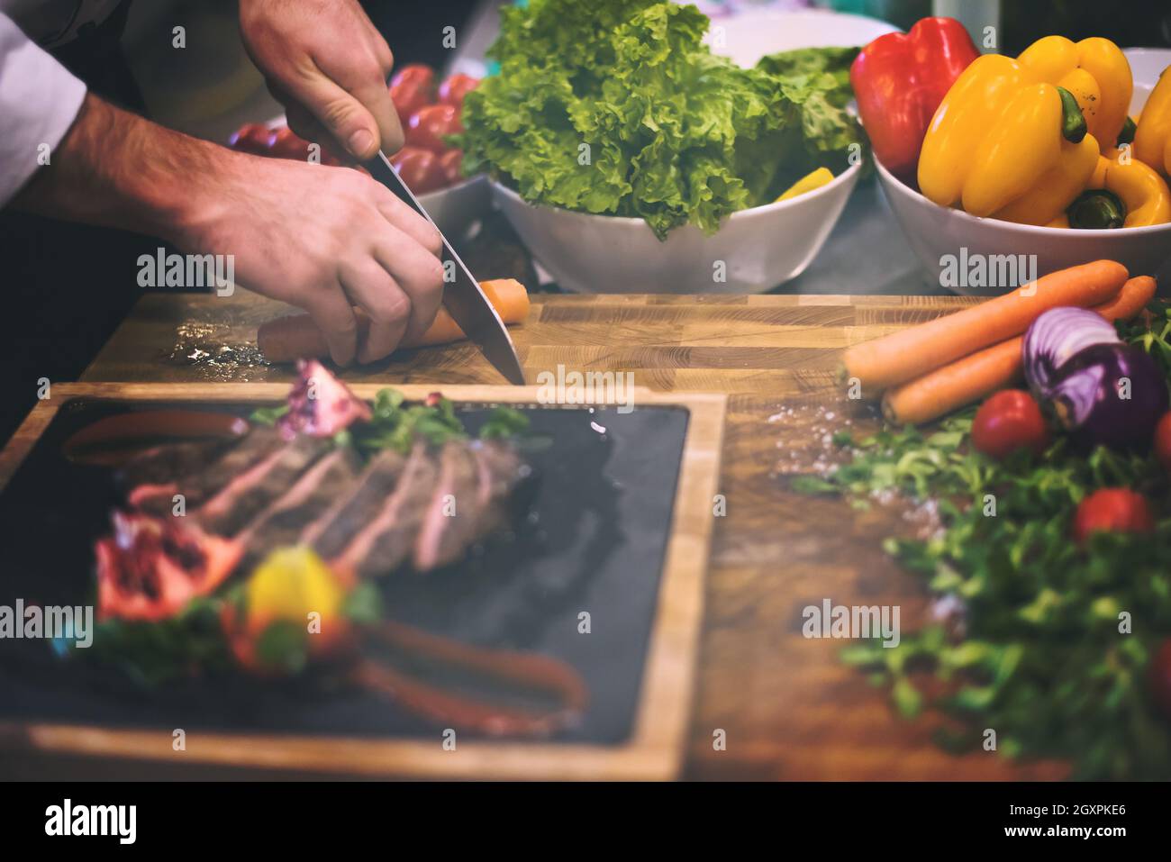 closeup of Chef hands in hotel or restaurant kitchen serving beef steak ...