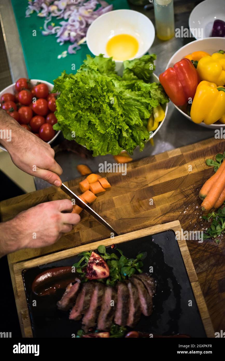top view of Chef hands in hotel or restaurant kitchen serving beef ...