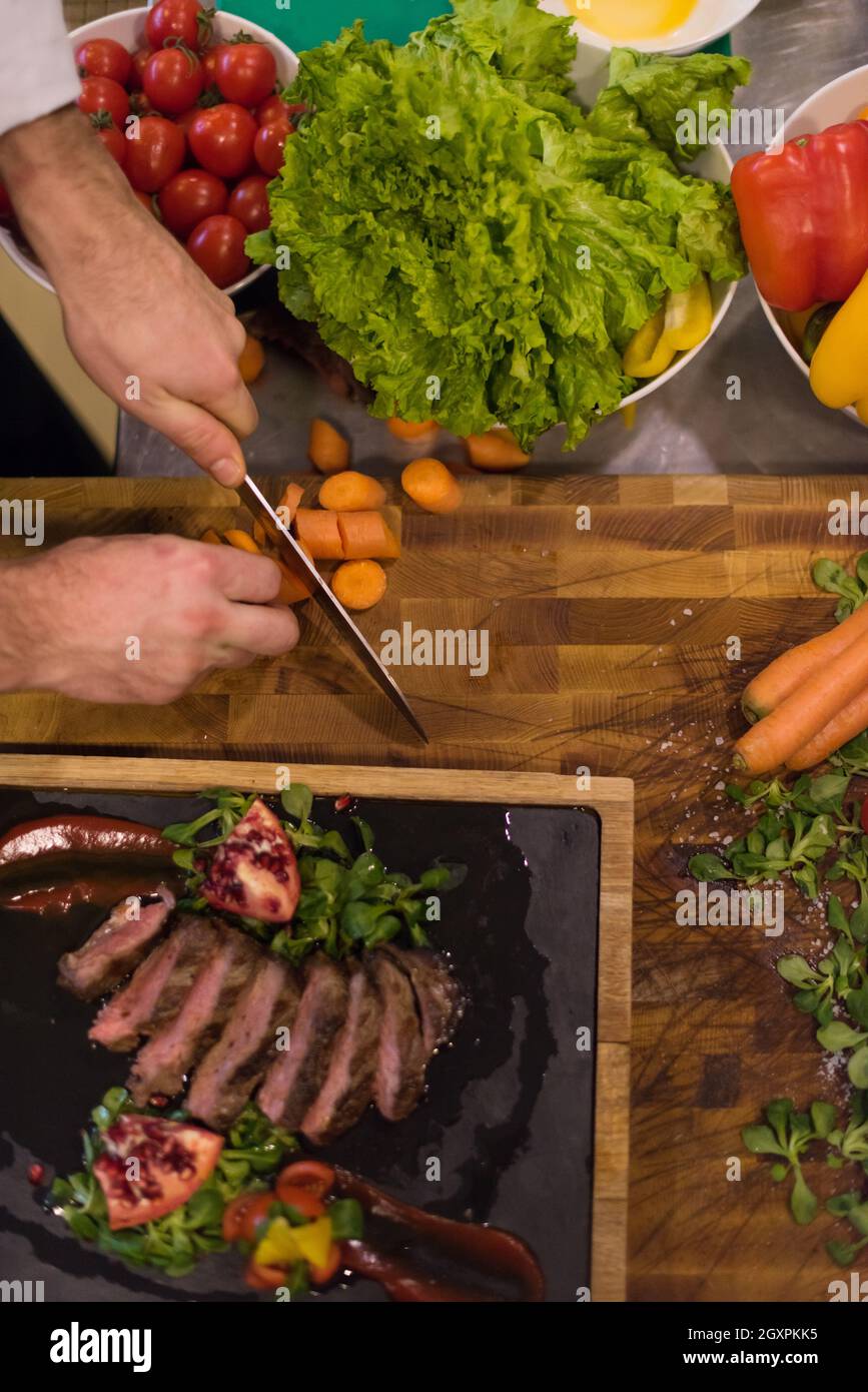 top view of Chef hands in hotel or restaurant kitchen preparing beef ...