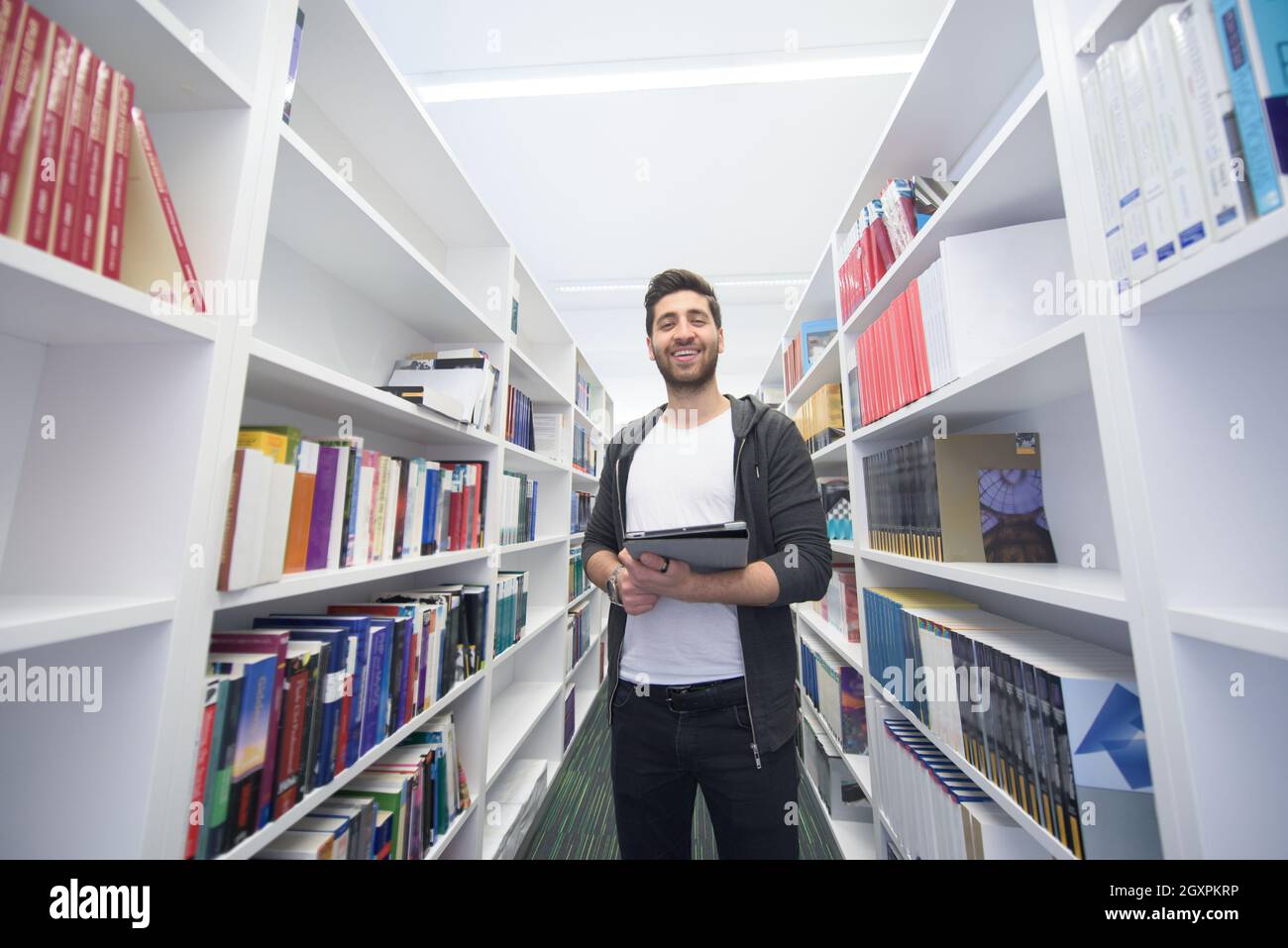 portrait of student in school library with tablet computer. Database ...