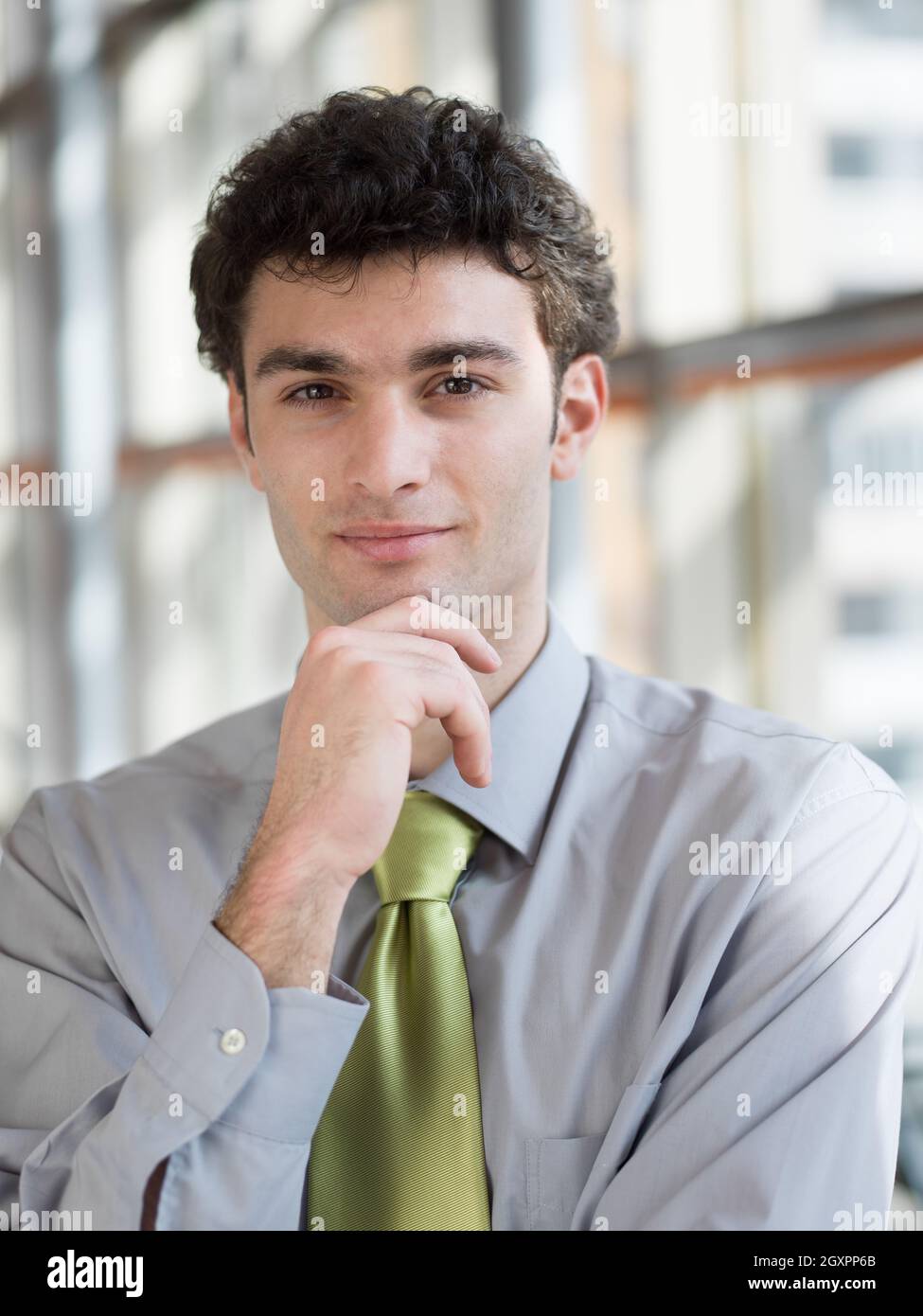 portrait of young business man at modern office interior with big ...